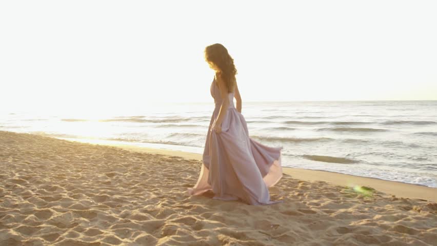 Beautiful Woman In White Dress Walking Along Beach In Waves Stock