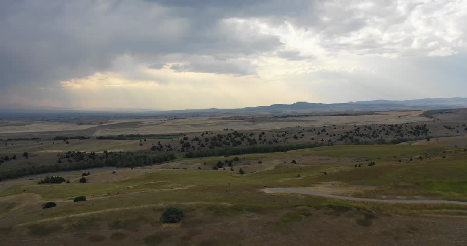 Clouds and farm landscape with town and mountains in Montana image ...