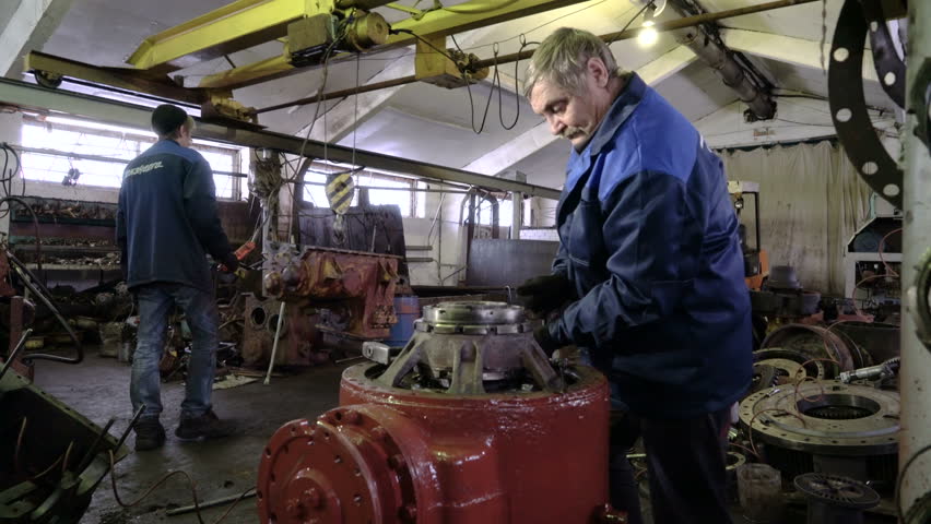 Work In The Heavy Machine Repair Shop. Professional Mechanic Checks The ...