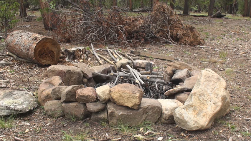 Starting Camp Fire In The Fire Pit Made Of Large Rock In Pine Forest In ...