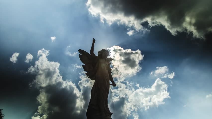 Angel Statue In The Sunset Light Against Fast Moving Clouds And Evening ...