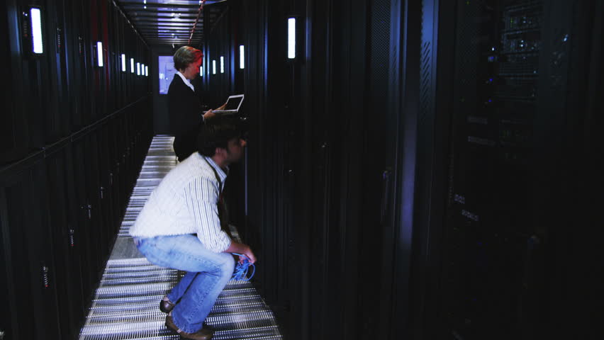 People Working In Computer Server Room Data Center. Walking Along Rows ...