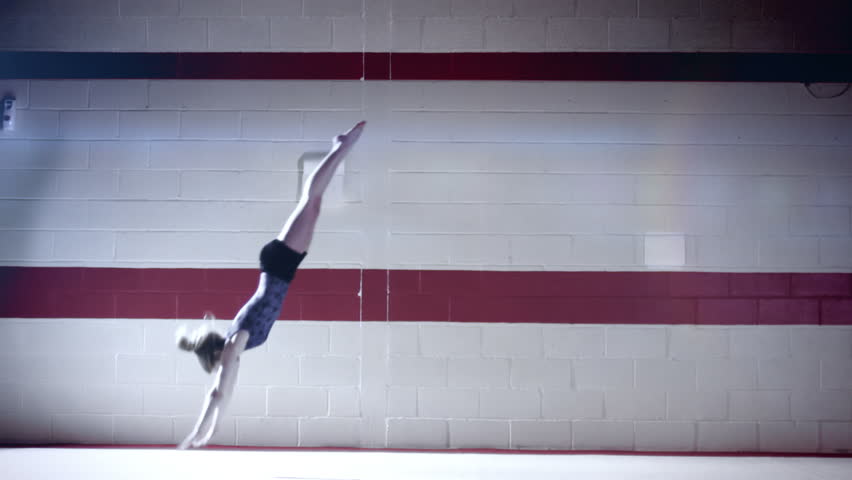 Female Gymnast Performing On A Balance Beam In Slow Motion. Olympics ...