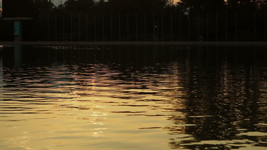 Dark Pond At Sunset In The Park With Reflecting Sunset Sky And A Rowing ...