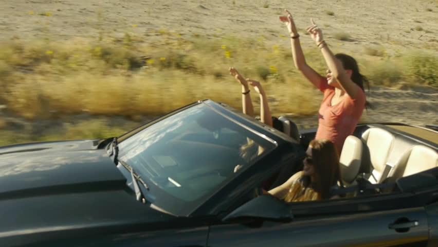 Girls Enjoy A Ride In A Convertible With Their Arms Raised Stock Footage Video 5719319