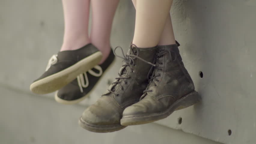 Closeup Of Two Teen's Feet Hanging Over The Edge Of A Wall, Hanging Out ...